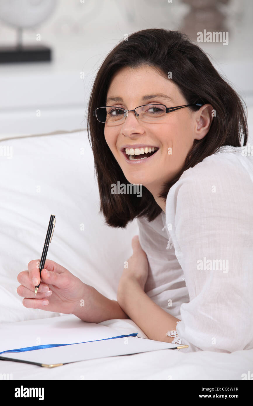 Smiling woman with notebook and pencil Stock Photo - Alamy