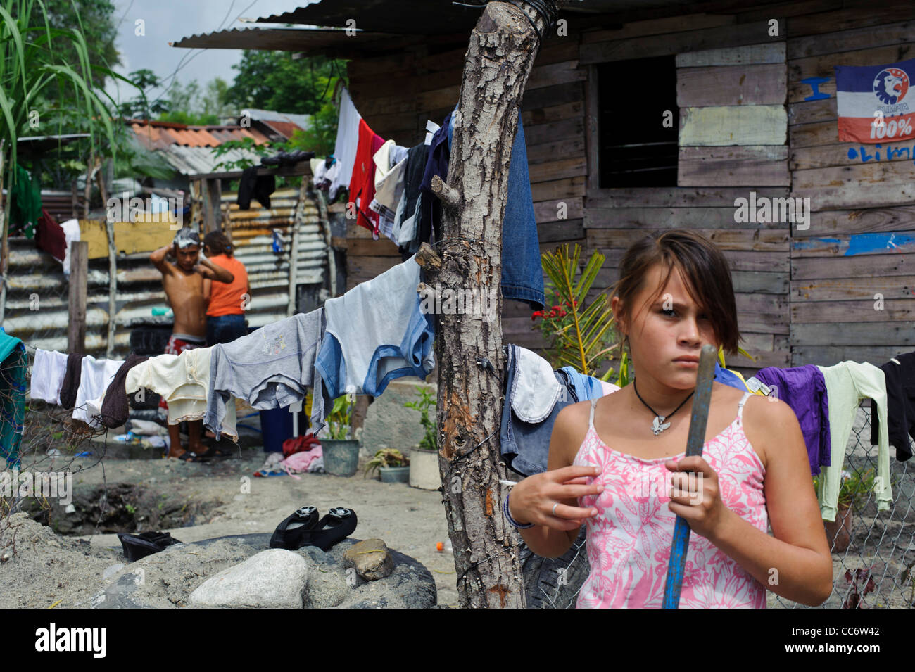 Girl with broom in the poor barrio of Los Bordos in San Pedro Sula ...