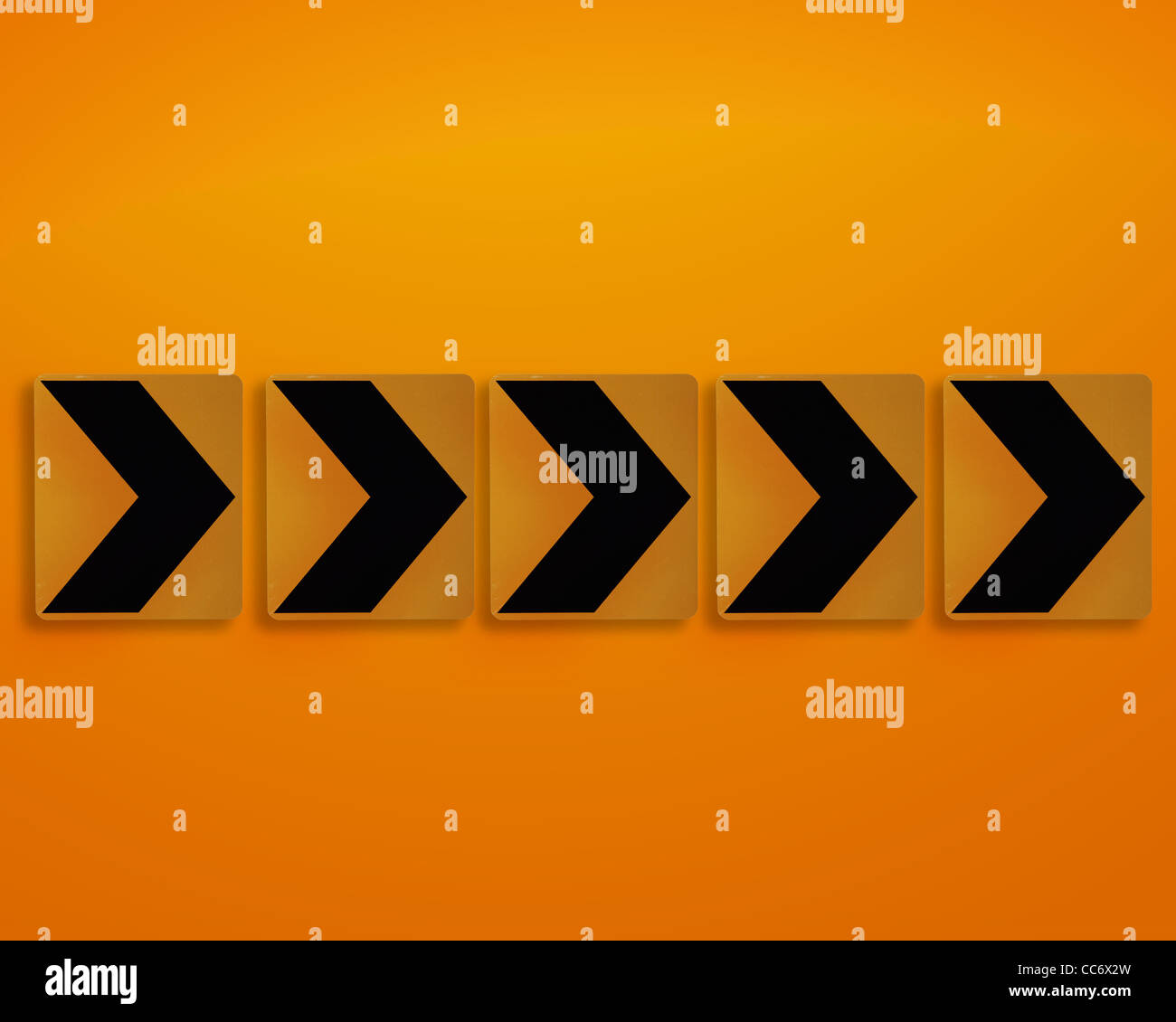 Orange direction signs on orange wall Stock Photo - Alamy