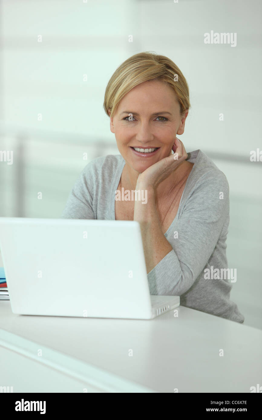 Blond woman in front of laptop computer Stock Photo - Alamy