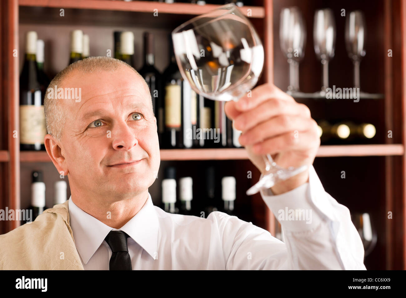 Wine bar waiter looking at clean glass in restaurant Stock Photo - Alamy