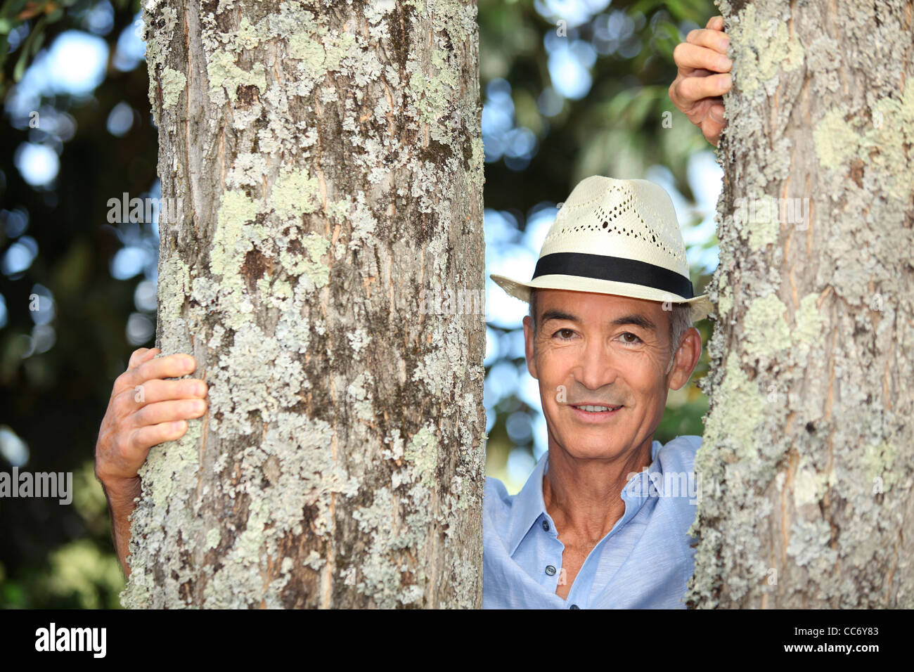 Old man stood between two trees Stock Photo - Alamy