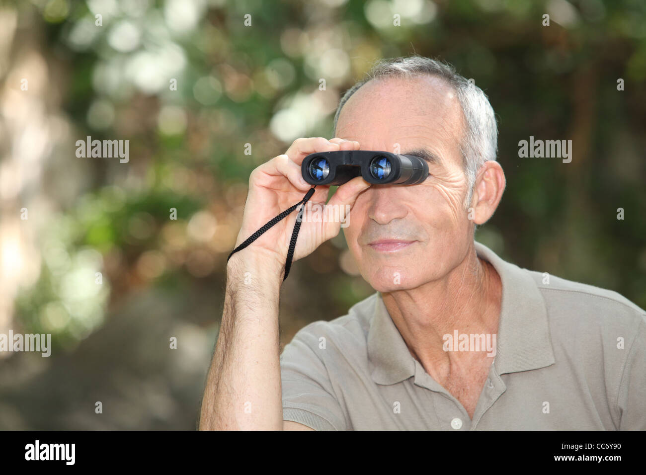 Man using a pair of binoculars Stock Photo - Alamy