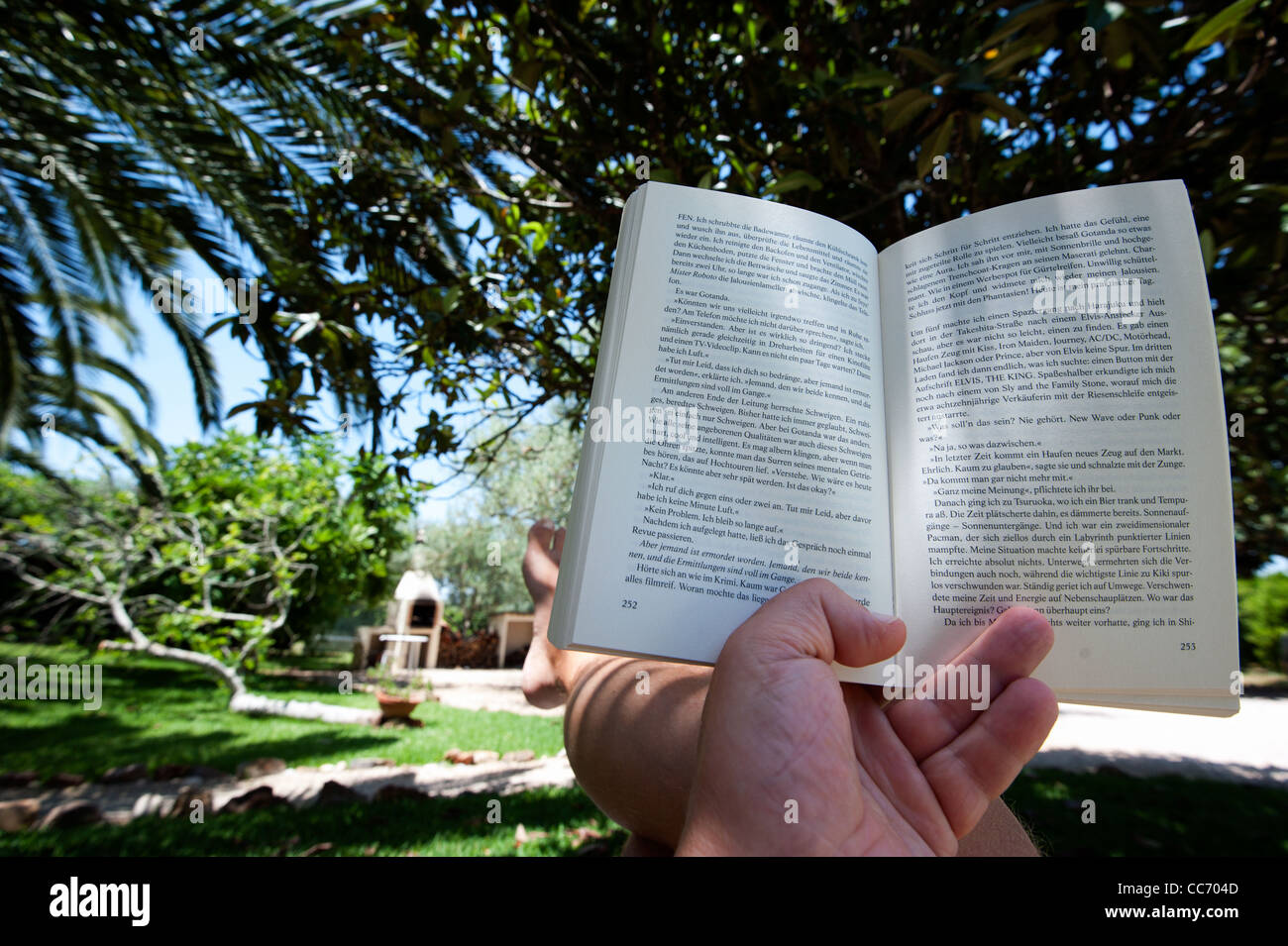Reading a book in a beautiful garden Stock Photo - Alamy
