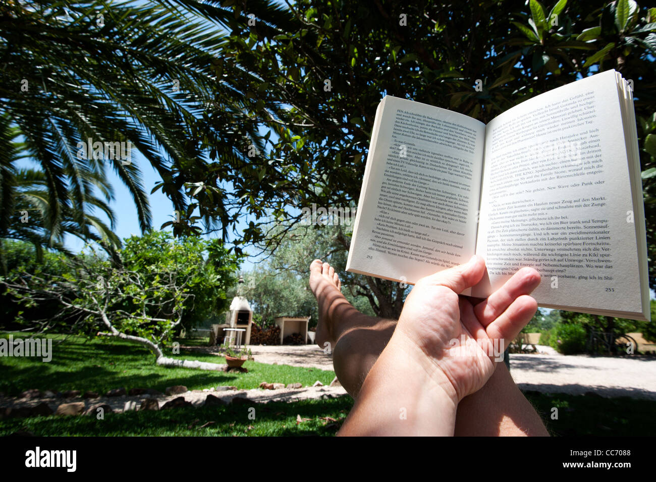 Reading a book in a beautiful garden Stock Photo - Alamy