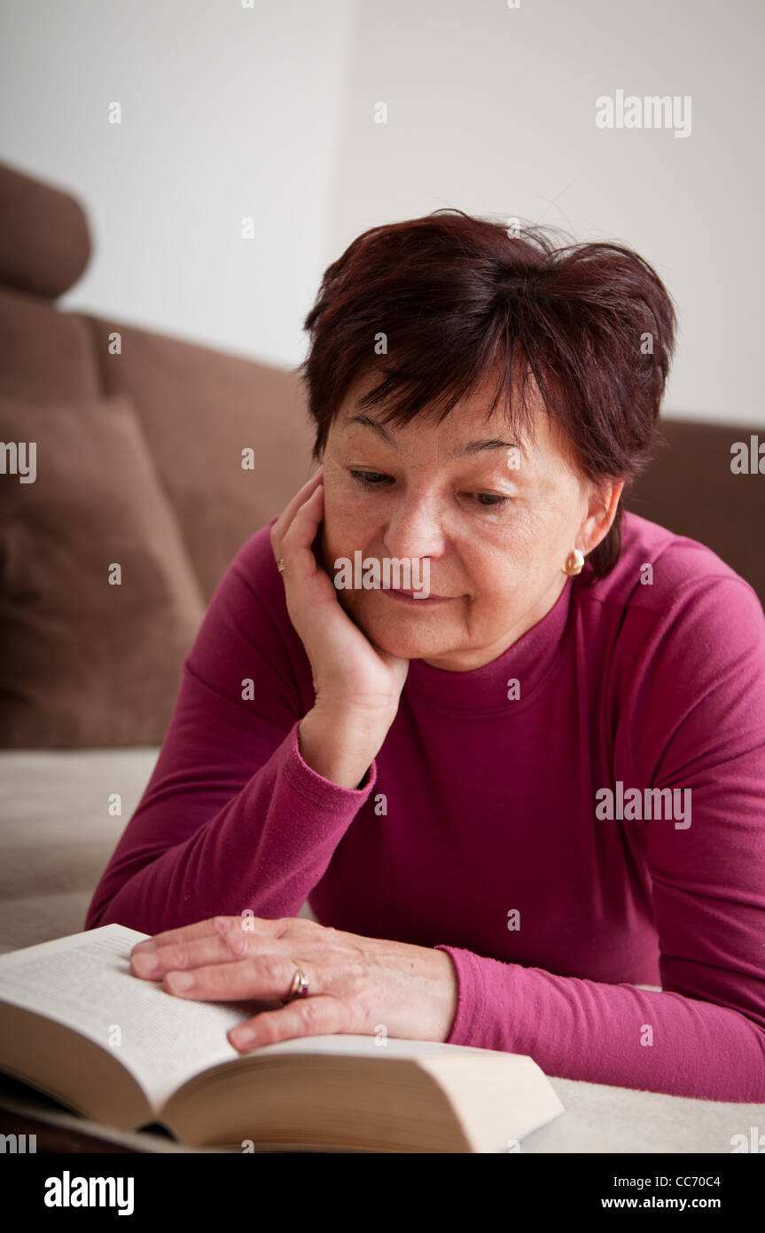 Senior woman reading book at home Stock Photo - Alamy
