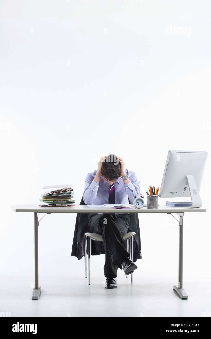 A stressful man while sitting on his desk Stock Photo - Alamy