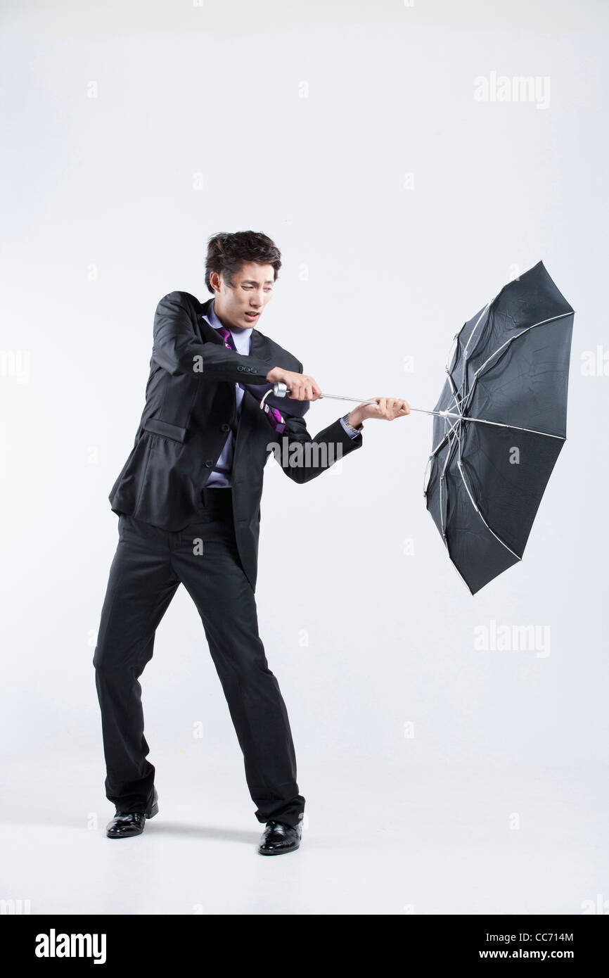 A man hit by the strong wind with an umbrella inside out Stock Photo ...