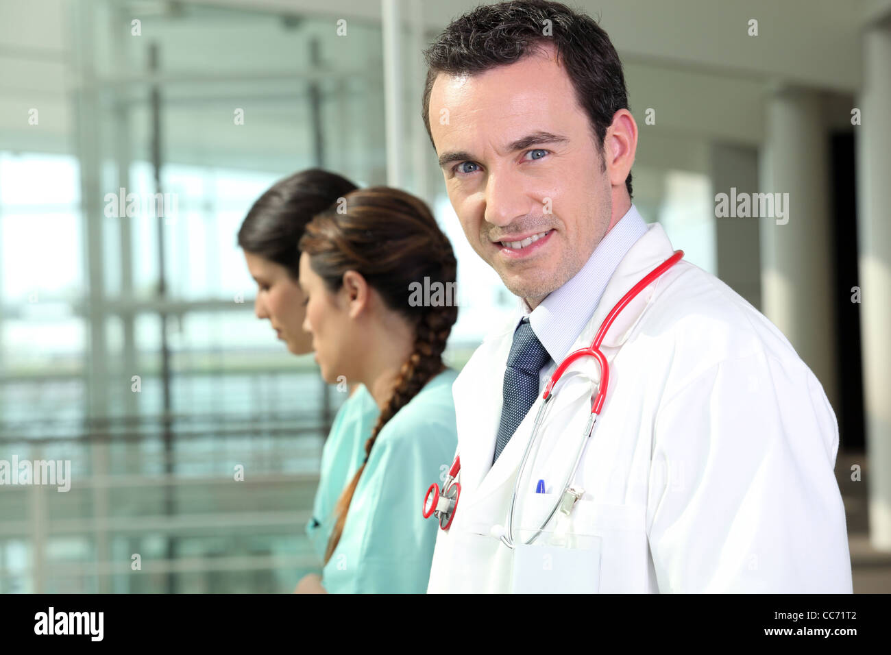 Doctor standing with two nurses Stock Photo - Alamy