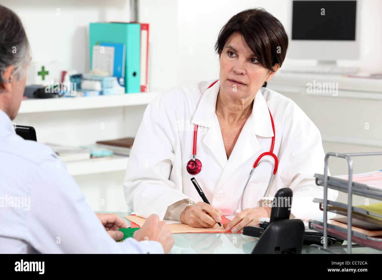 Doctor consulting with a patient Stock Photo - Alamy