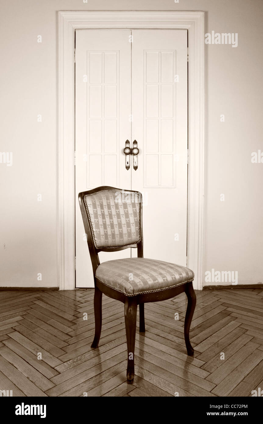 Vintage wooden chair in the room in front of the closed door Stock ...