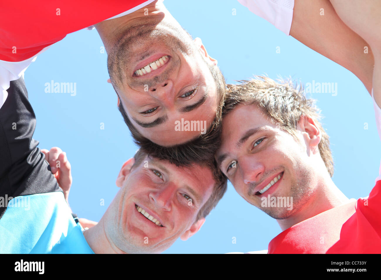 Guys with heads together Stock Photo - Alamy