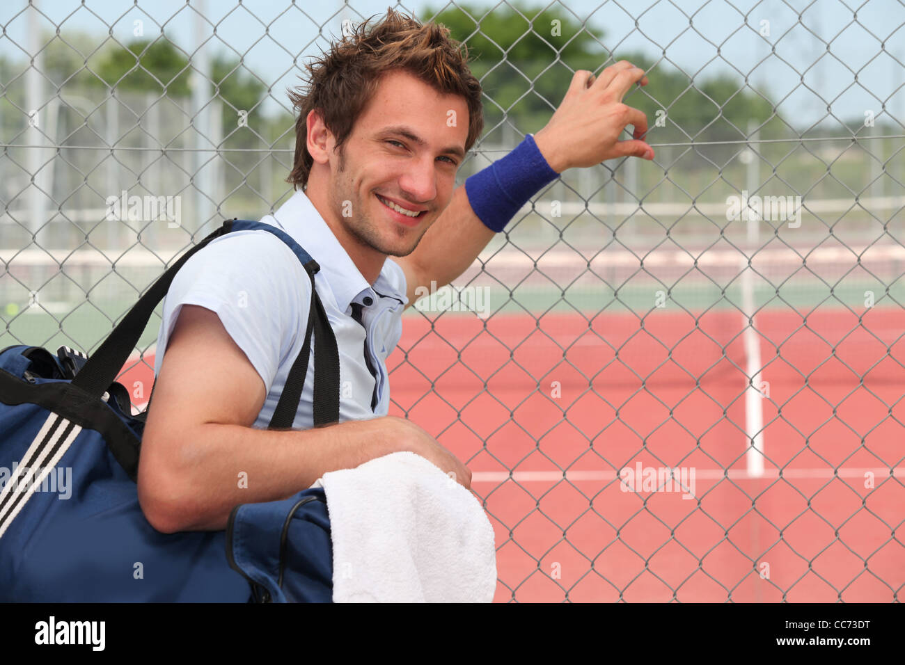 Tennis player leaning against fence Stock Photo - Alamy