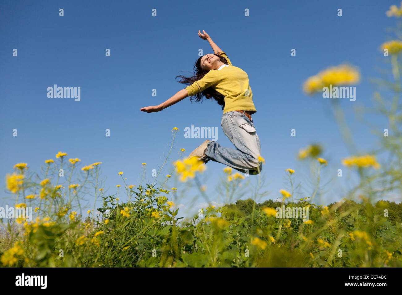 Happy and beautiful young girl jumping high in a summer field Stock ...