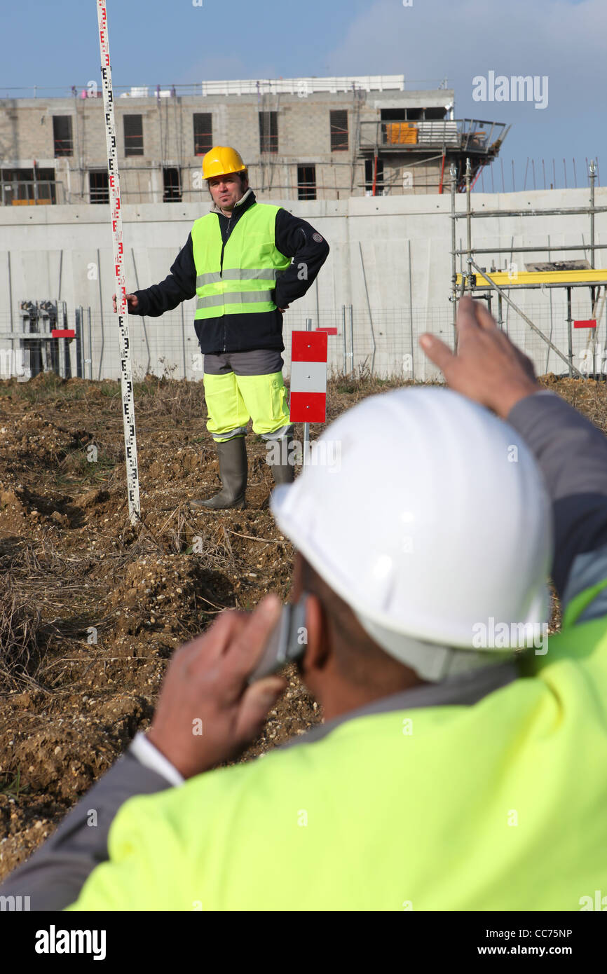 Two men measuring construction site Stock Photo - Alamy