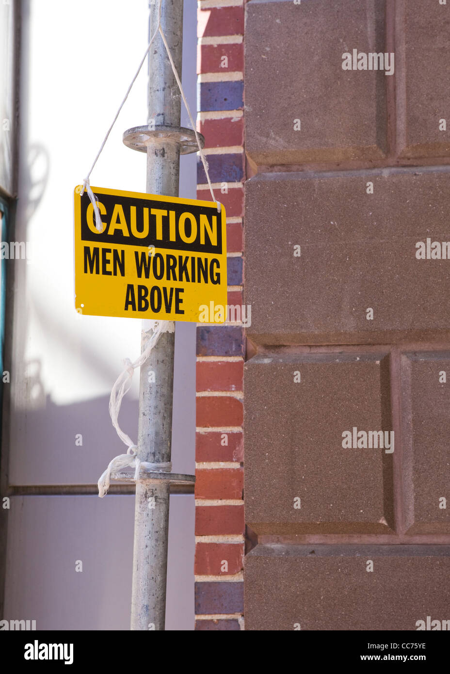 Men working above sign Stock Photo - Alamy