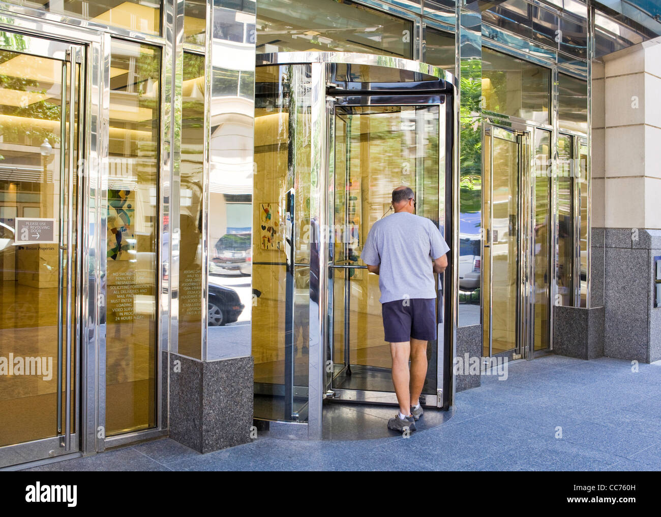 A man walking through a revolving door Stock Photo - Alamy