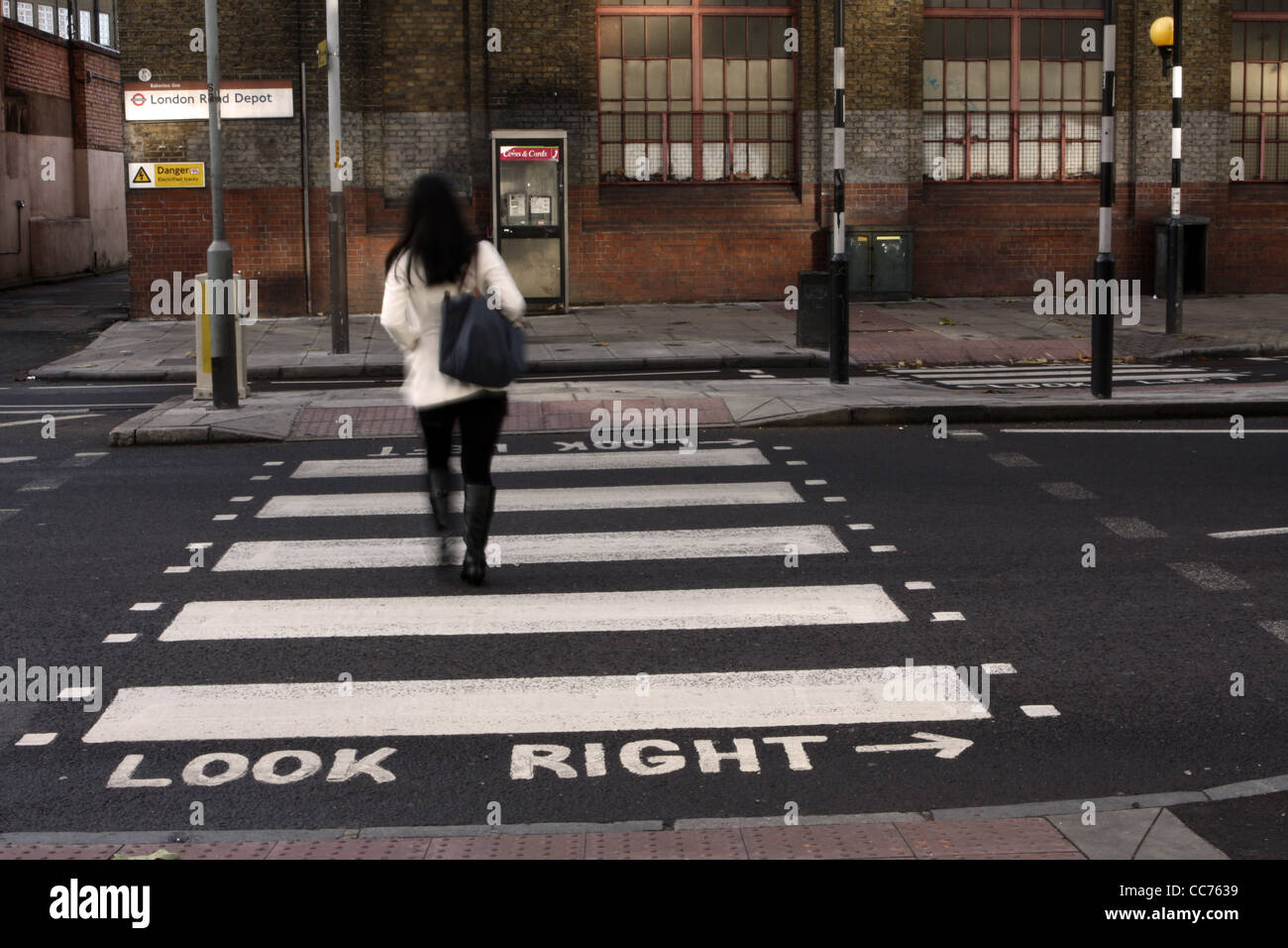 a female walks across a zebra crossing in London Stock Photo - Alamy