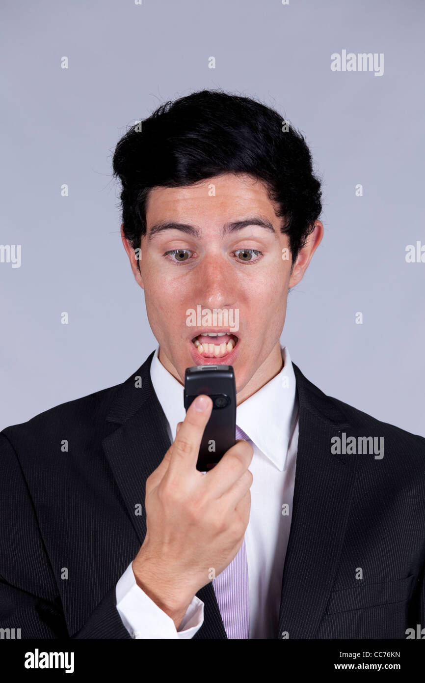 Angry Businessman talking on his cellular (isolated on gray Stock Photo ...