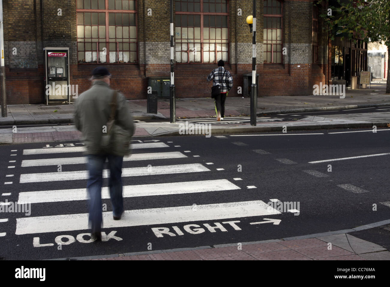 a man walks across a zebra crossing in London Stock Photo - Alamy