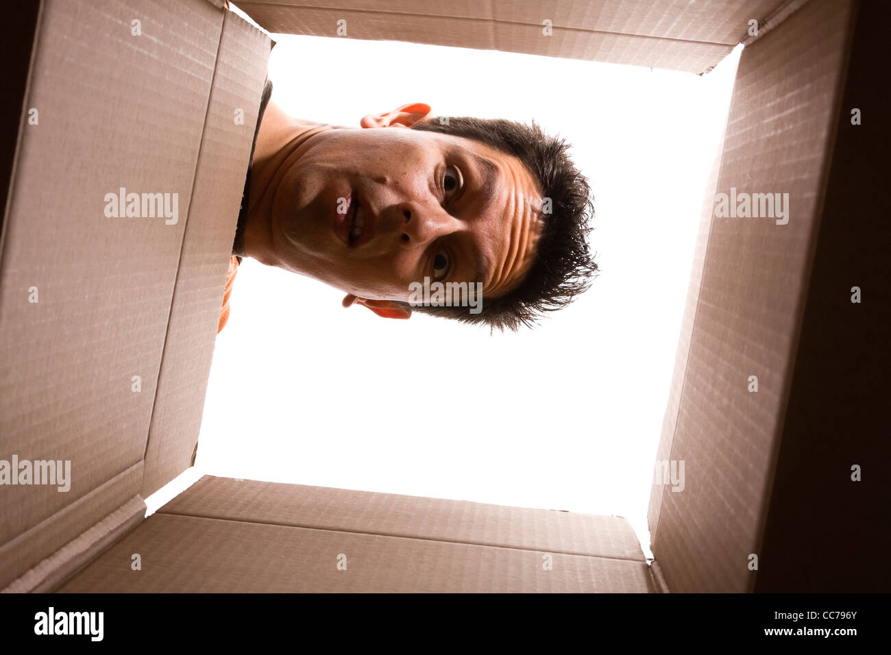young man looking inside a cardboard box Stock Photo - Alamy