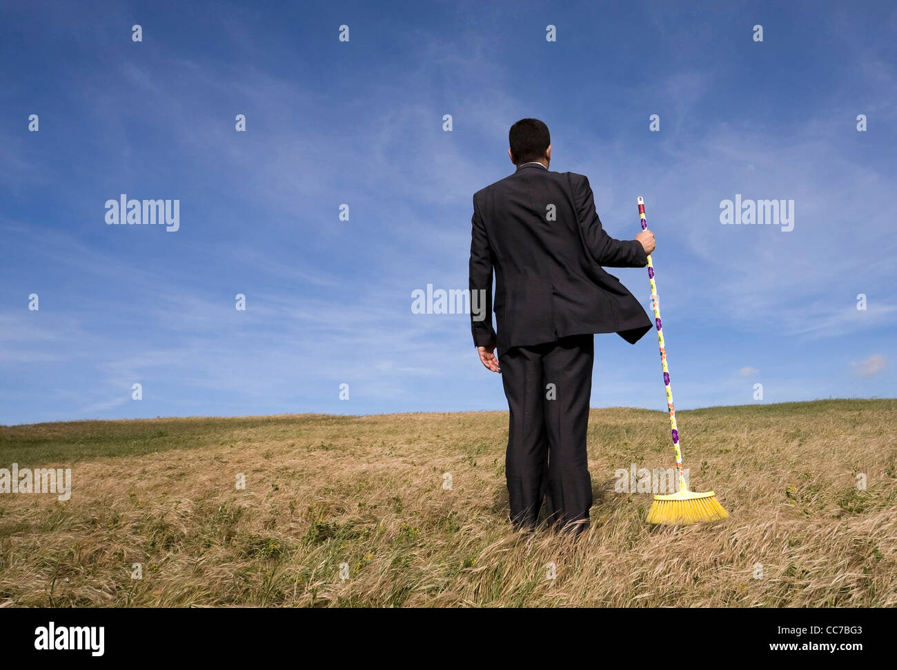 businessman cleaning the field with a broom Stock Photo - Alamy