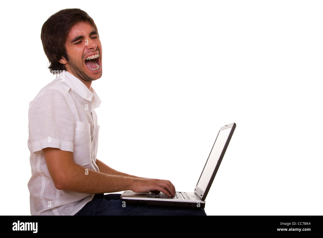 one young men screaming at his computer (isolated on white Stock Photo ...