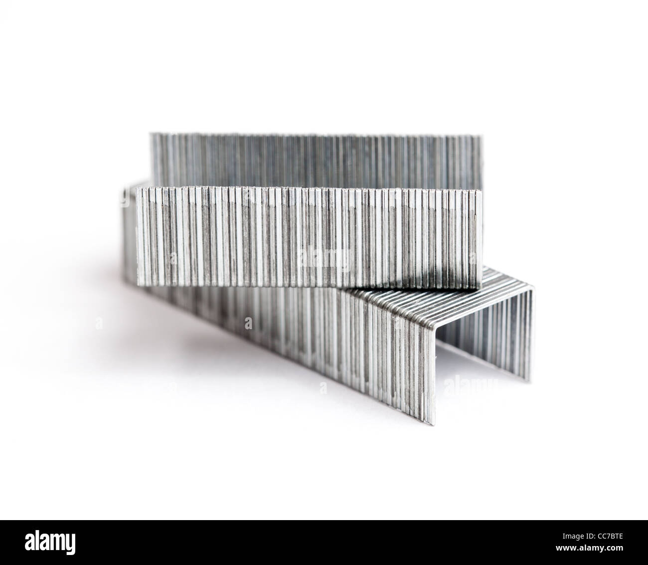 Two rows of paper staples lying on top of each other and isolated in ...