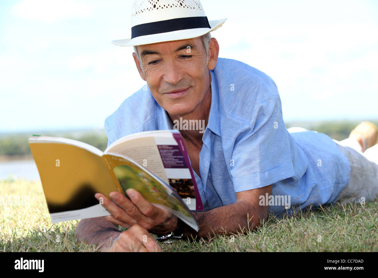 elderly gentleman lying on grass reading tourist guide Stock Photo - Alamy
