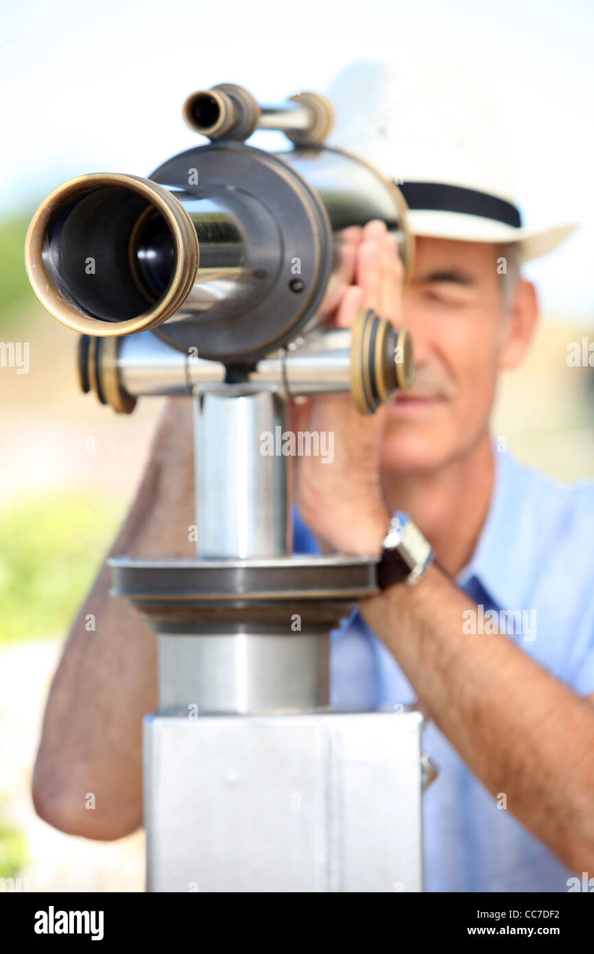 Middle-aged man looking through telescope Stock Photo - Alamy
