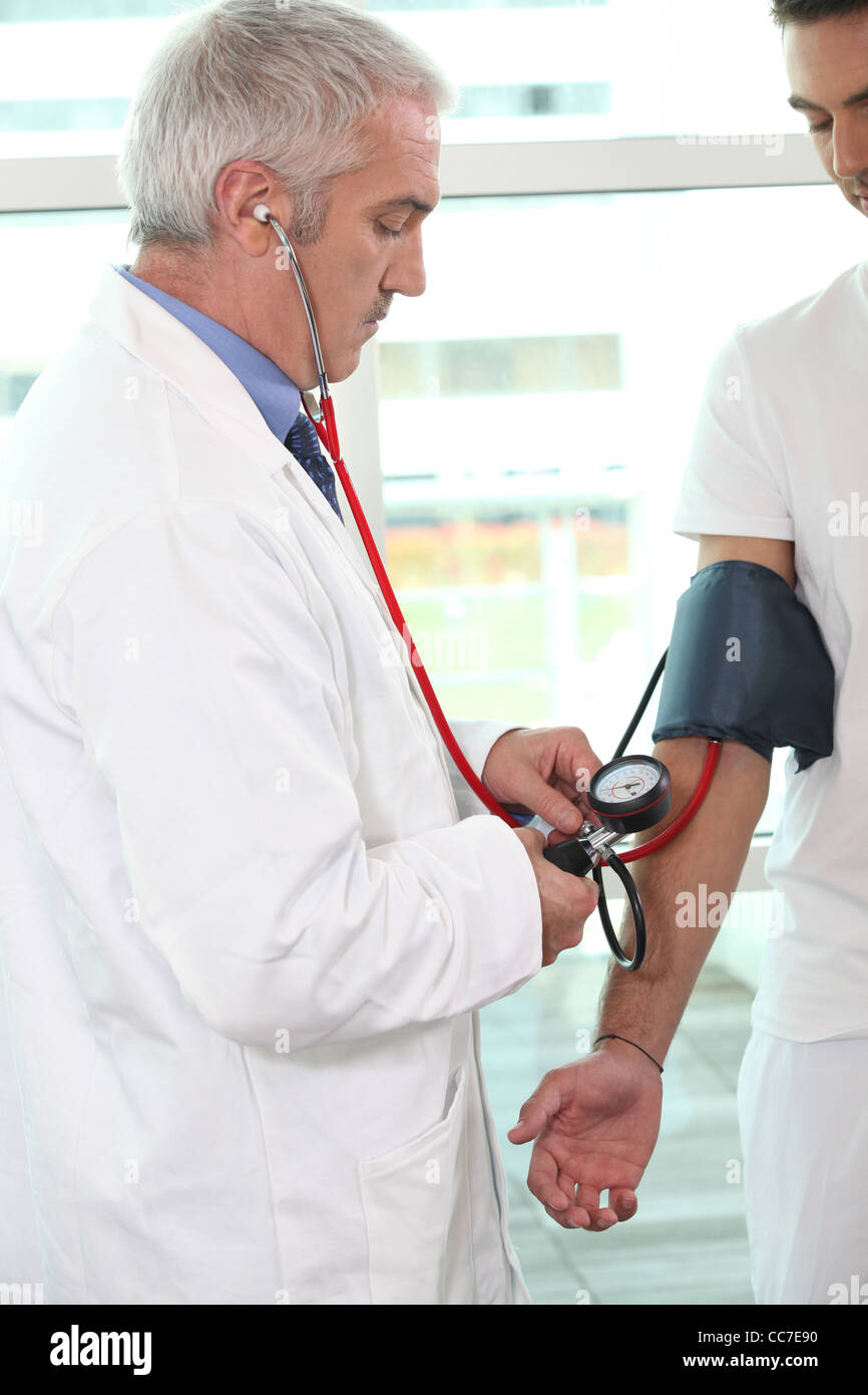 Doctor checking a patient's blood pressure Stock Photo - Alamy