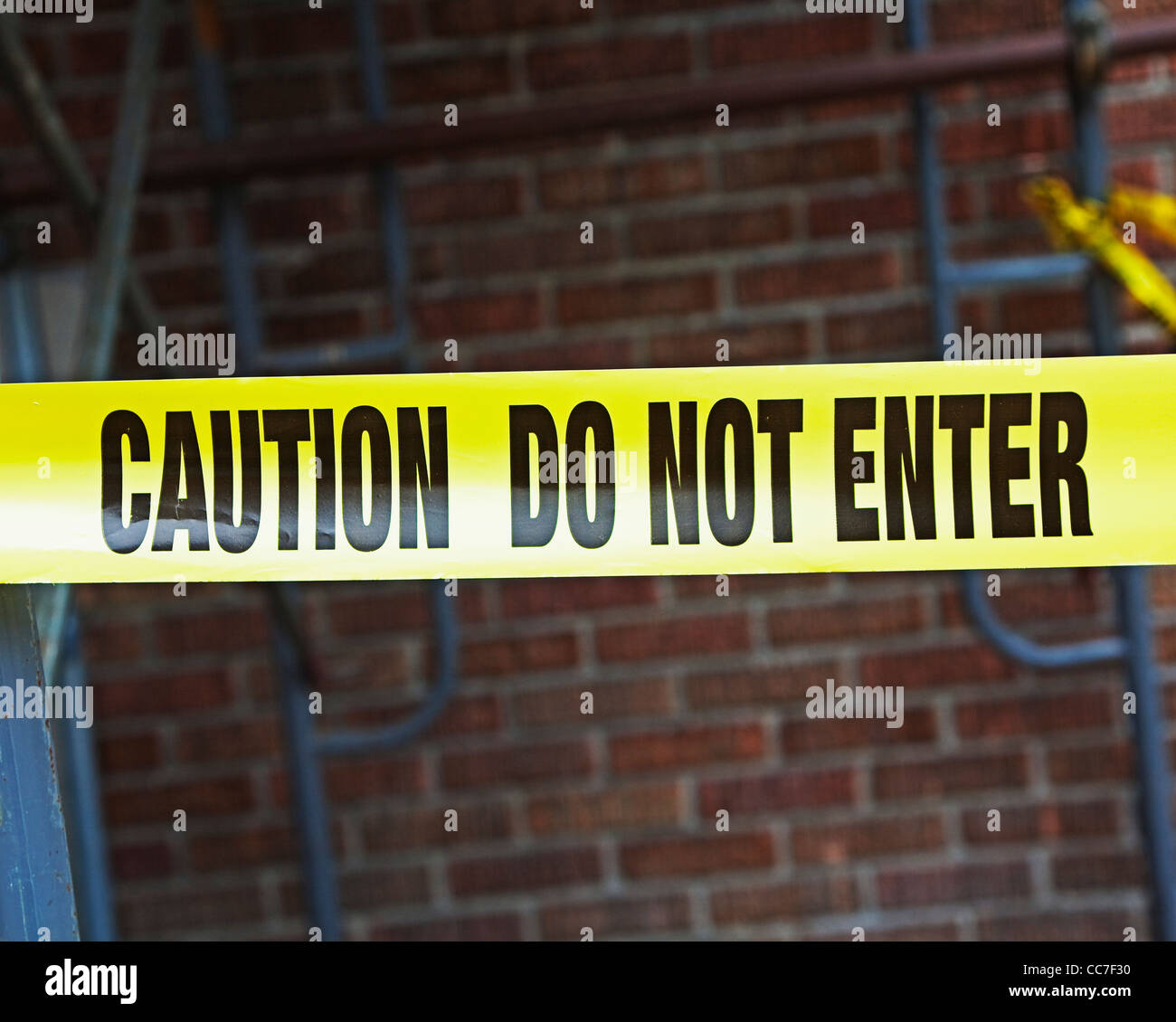 caution do not enter tape in front of scaffolding and brick wall Stock ...