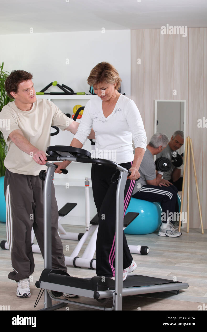 Mature woman using a treadmill Stock Photo - Alamy