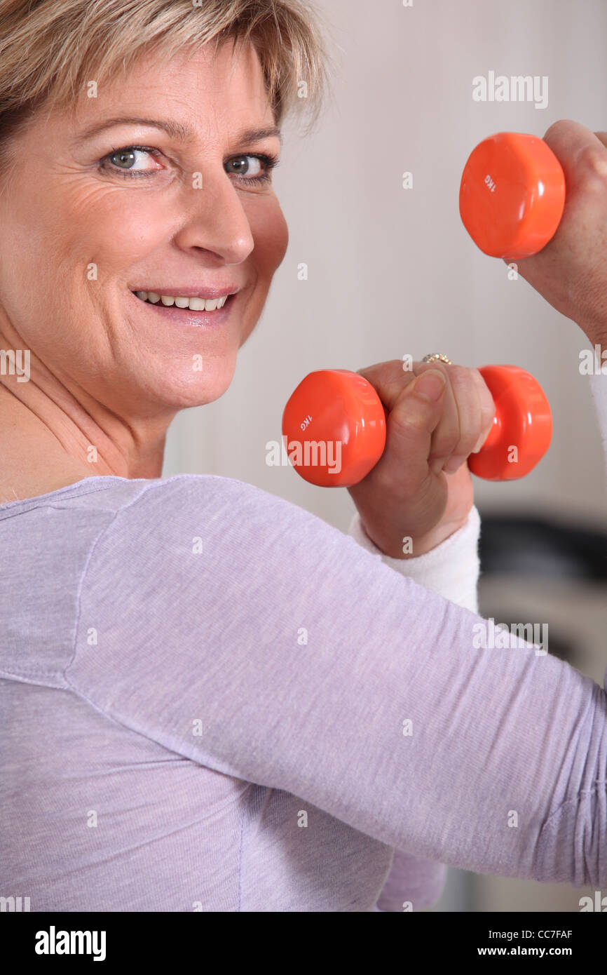 Mature woman using dumbbells hi-res stock photography and images - Alamy