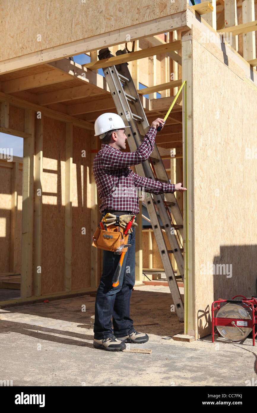Contractor inspecting woodwork on house under construction Stock Photo ...