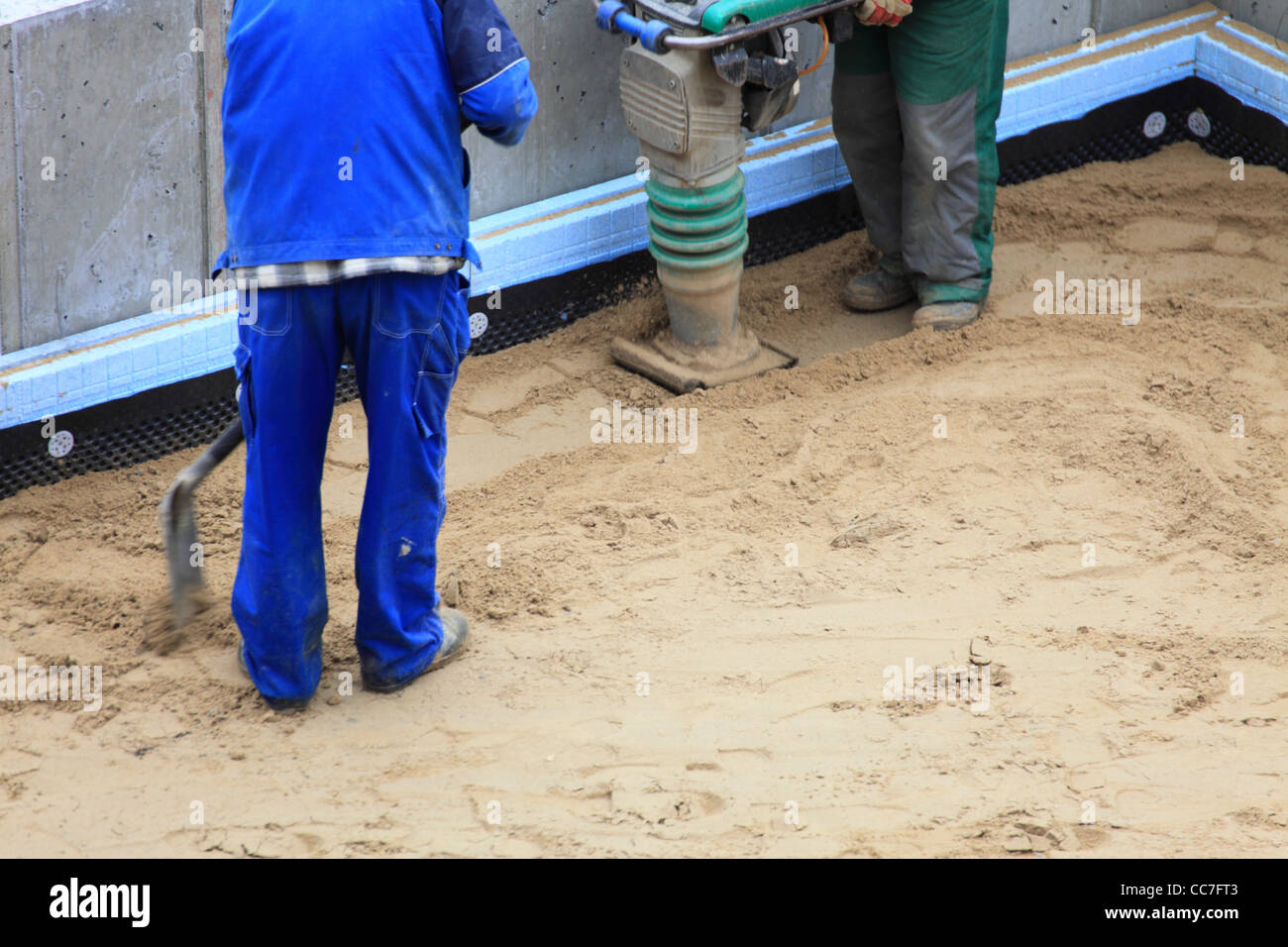 Worker at site working with compress tool - sand Stock Photo - Alamy
