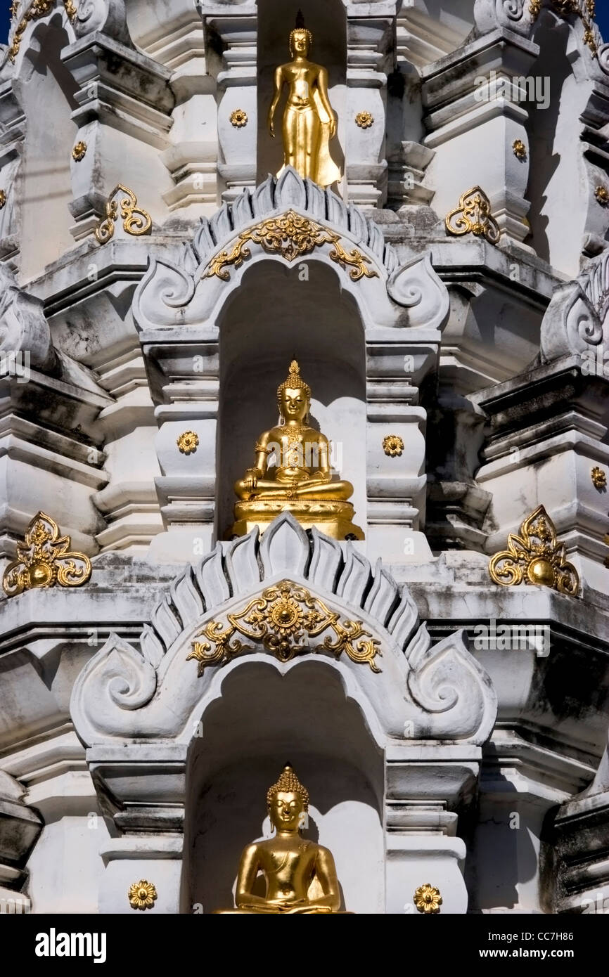 A stupa with gold Buddha statues is on display at a Buddhist temple in ...