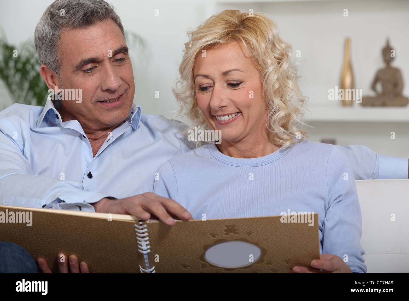 Middle-aged couple looking through photo-album Stock Photo - Alamy