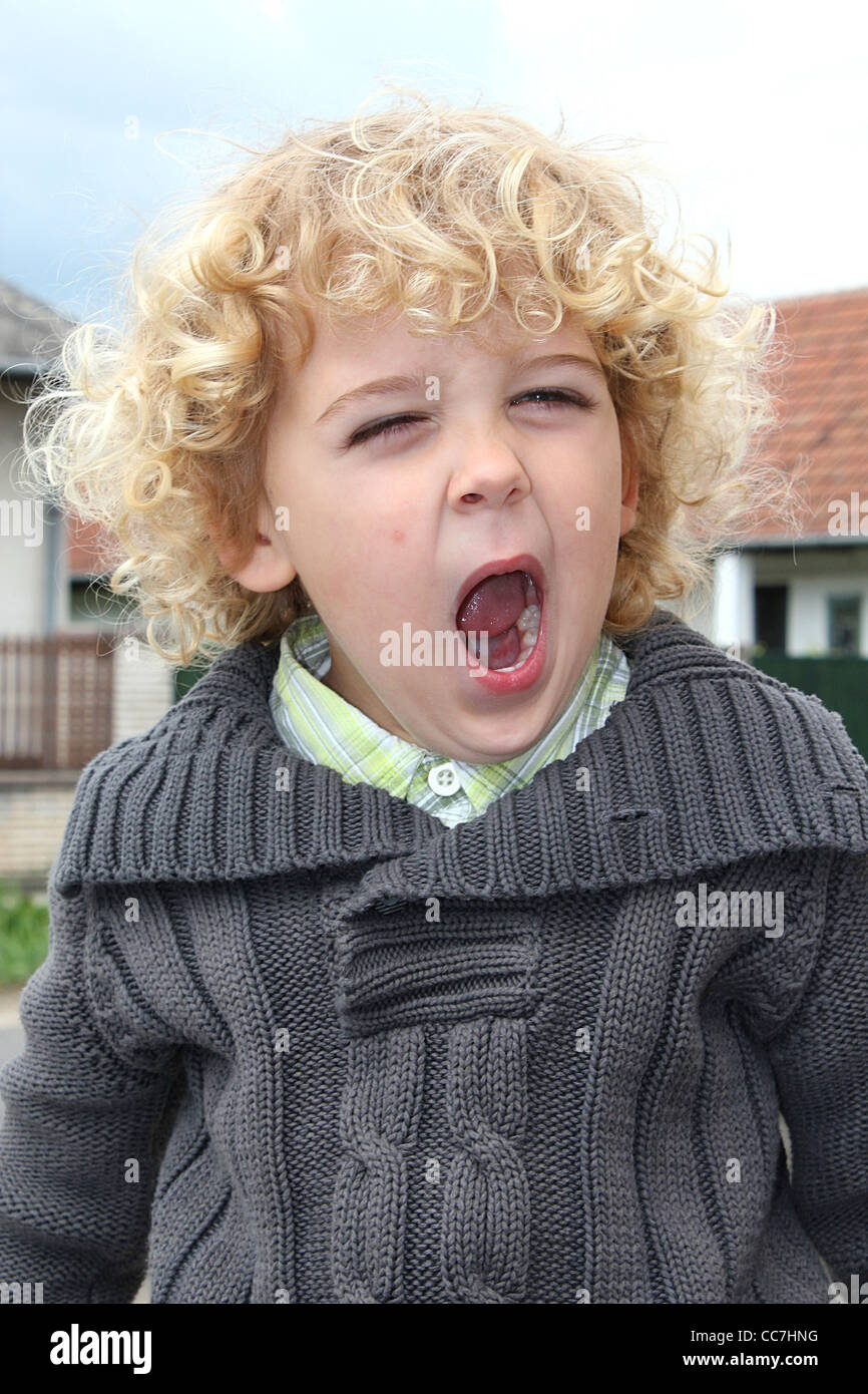 portrait of an adorable little boy yawning Stock Photo - Alamy