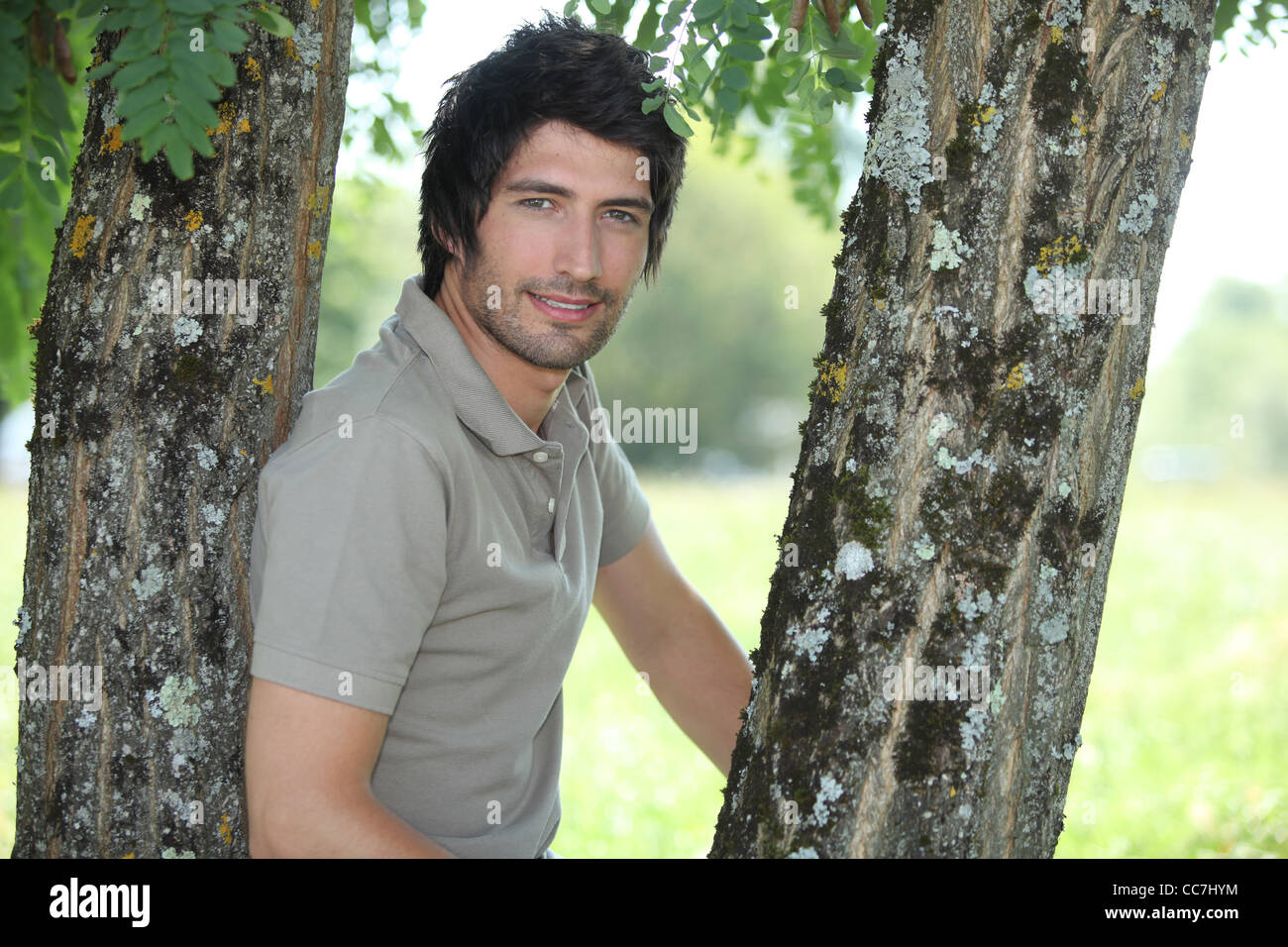 Man standing between trees Stock Photo - Alamy