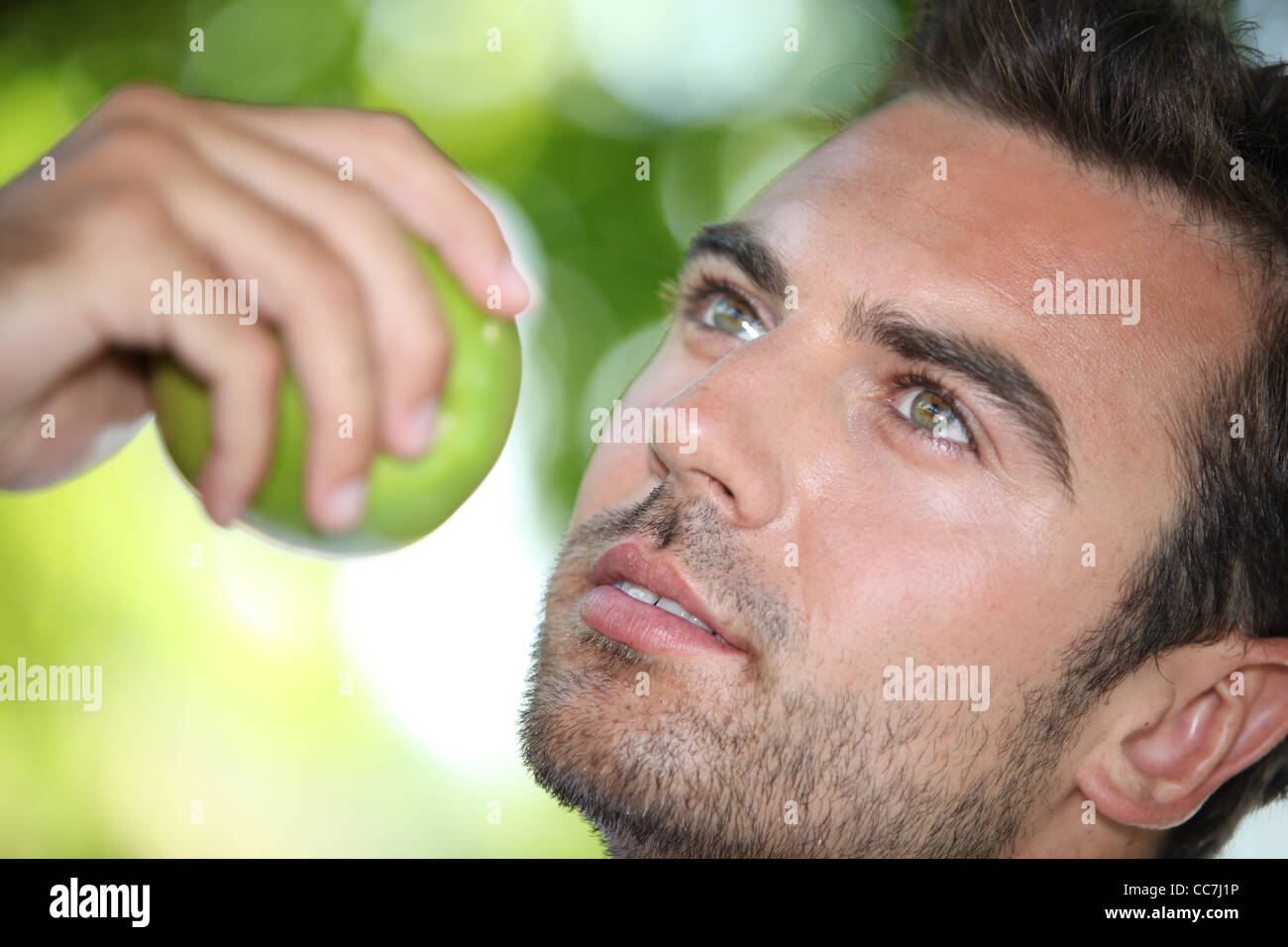 Pensive man eating an apple Stock Photo - Alamy