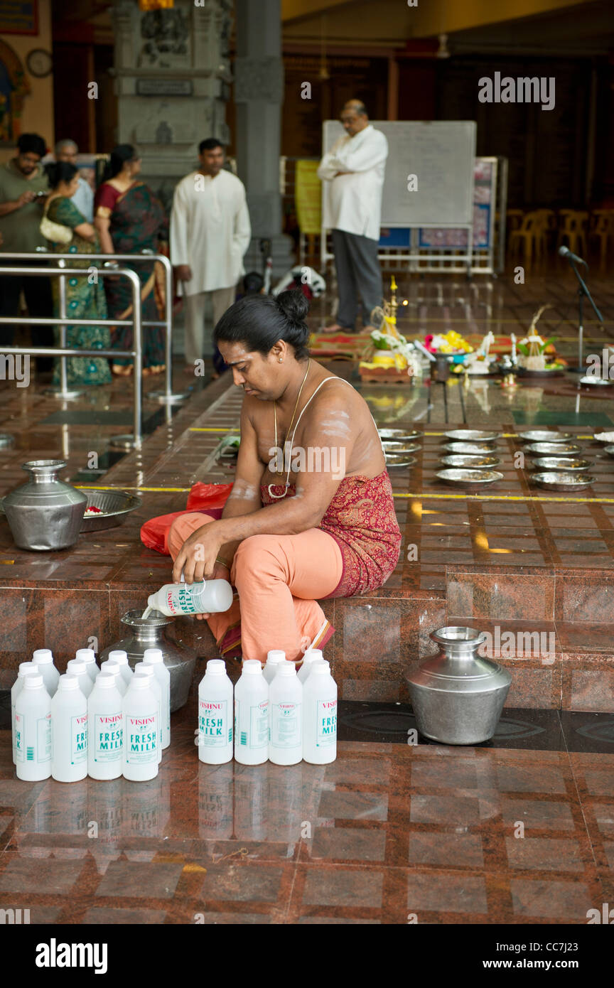 High priest emptying milk bottles, Sri Senpaga Vinayagar Temple ...