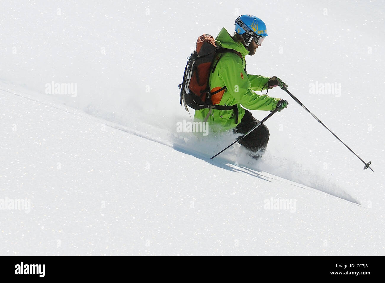 A telemark skier in action in deep powder, off piste in the ski resort ...