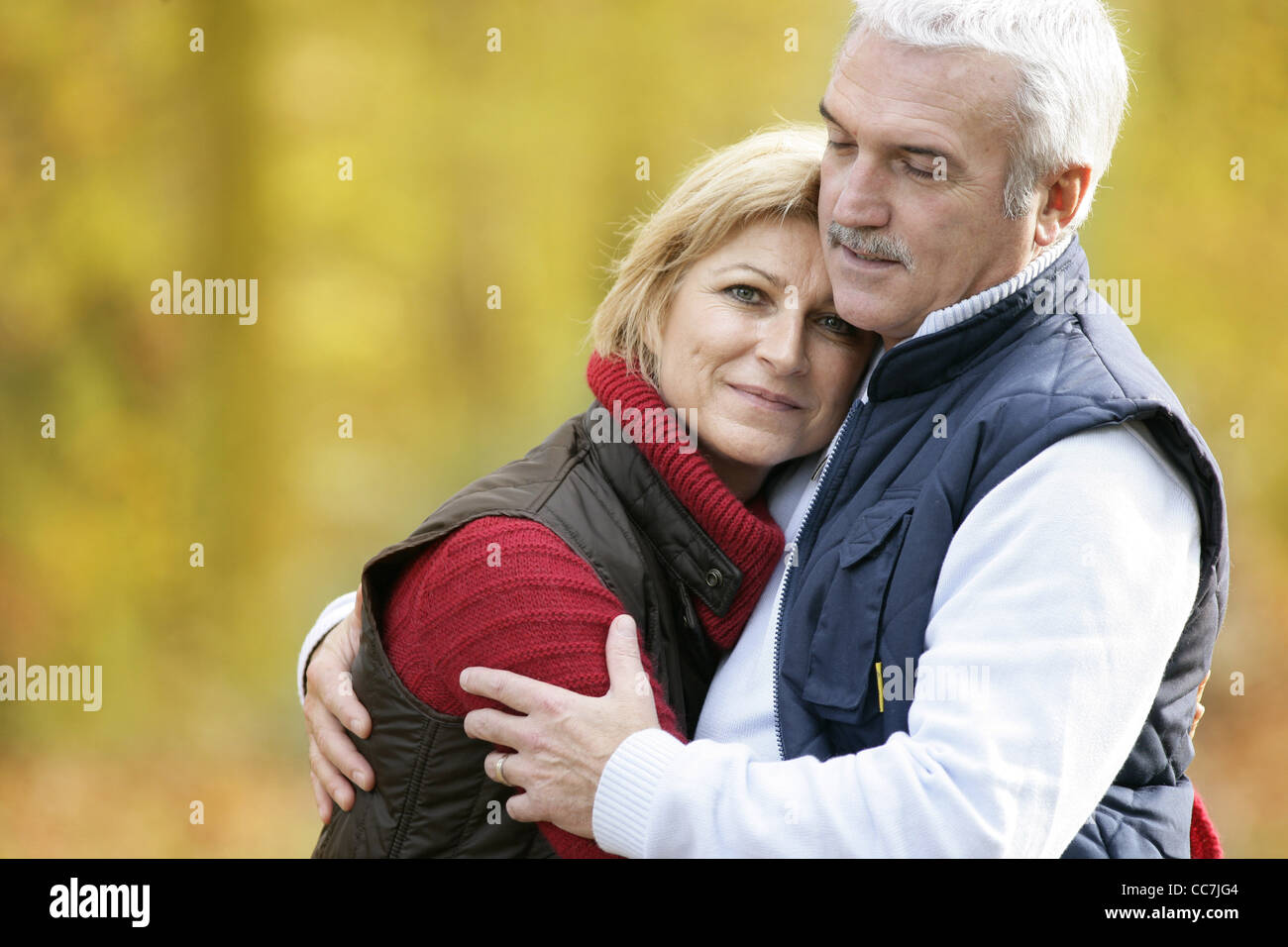 Elderly couple cuddling in park Stock Photo - Alamy