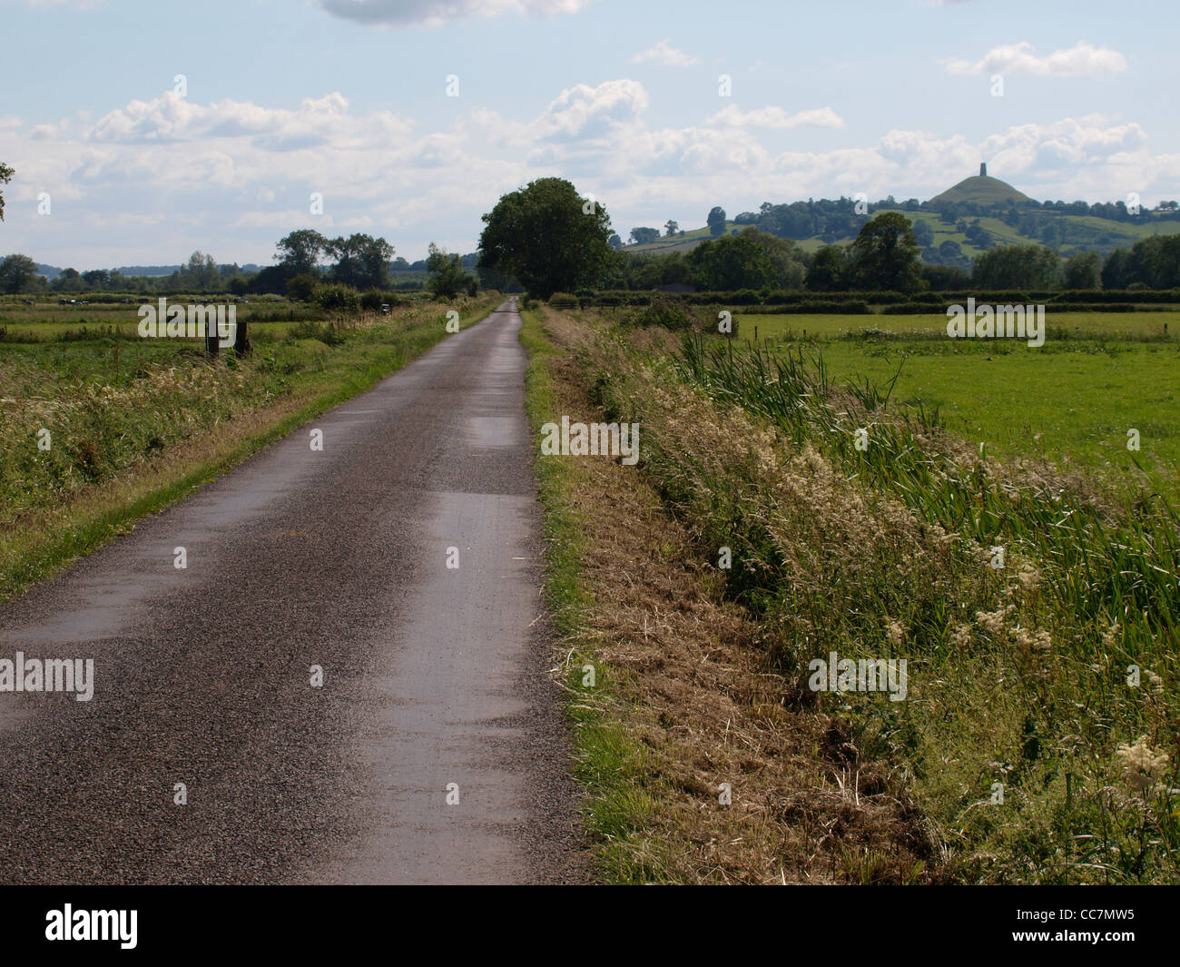 Country road with Glastonbury tor in the distance, Somerset, UK Stock ...