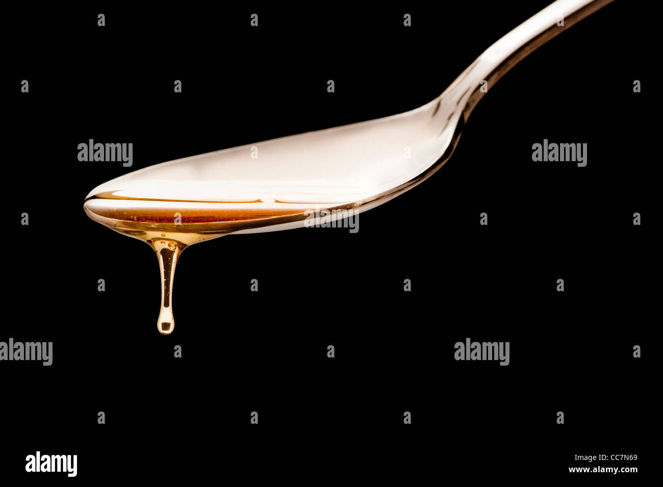 Spoon with dripping honey Stock Photo - Alamy