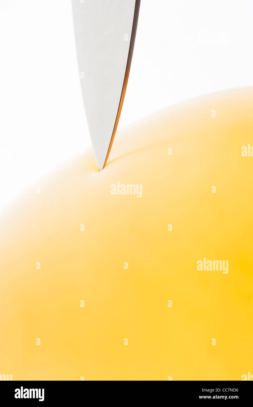 Yellow balloon and sharp knife Stock Photo - Alamy