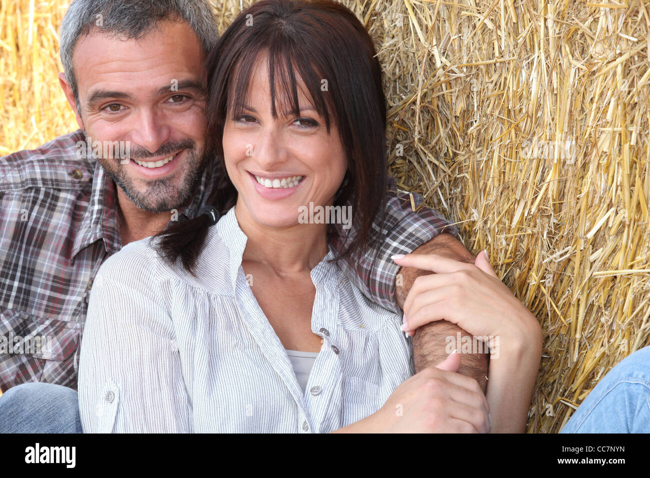 Farming couple sitting in the hay Stock Photo - Alamy