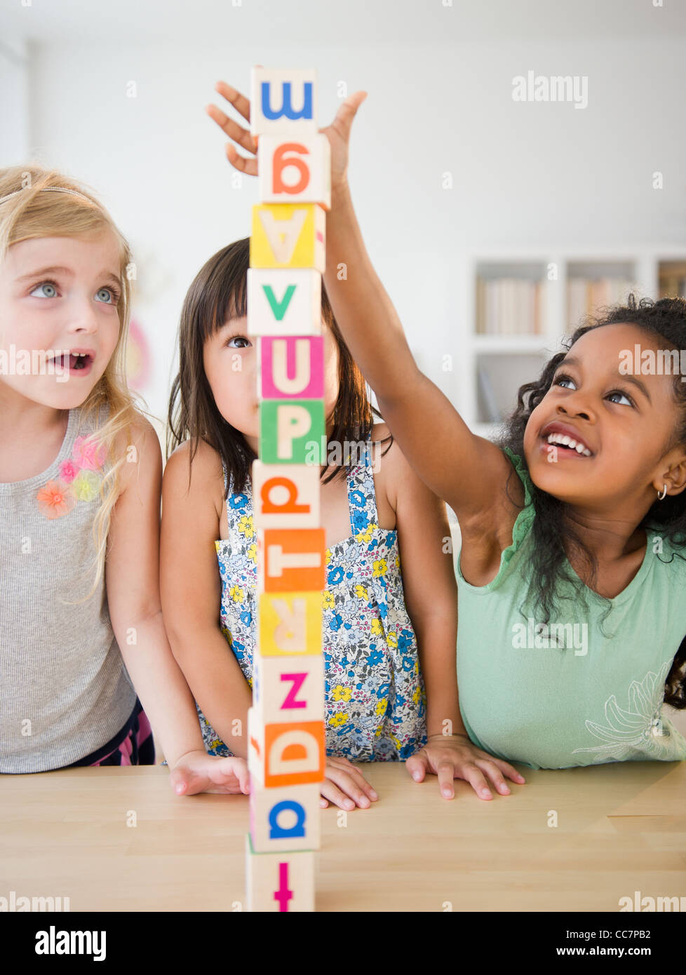 Girls stacking alphabet blocks together Stock Photo - Alamy