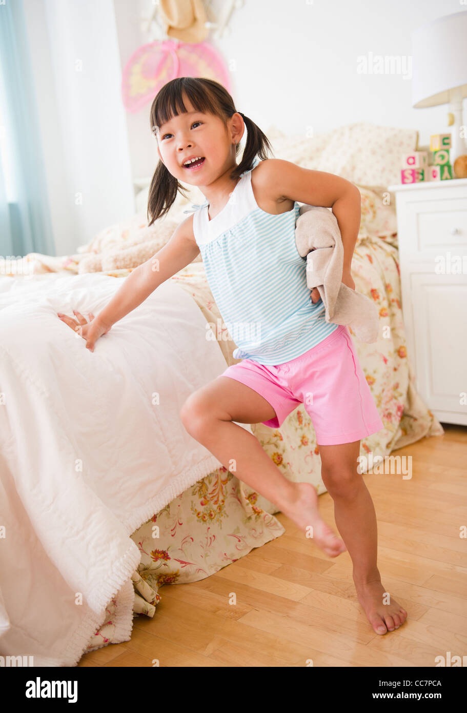 Korean girl leaning against bed in bedroom Stock Photo - Alamy